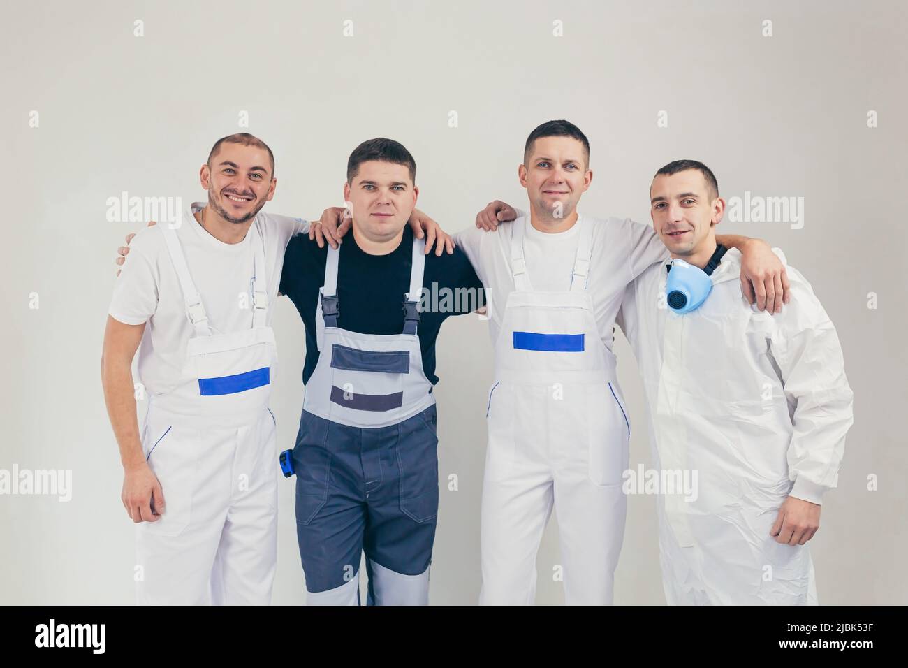 A team of construction workers, four people, men performing ...