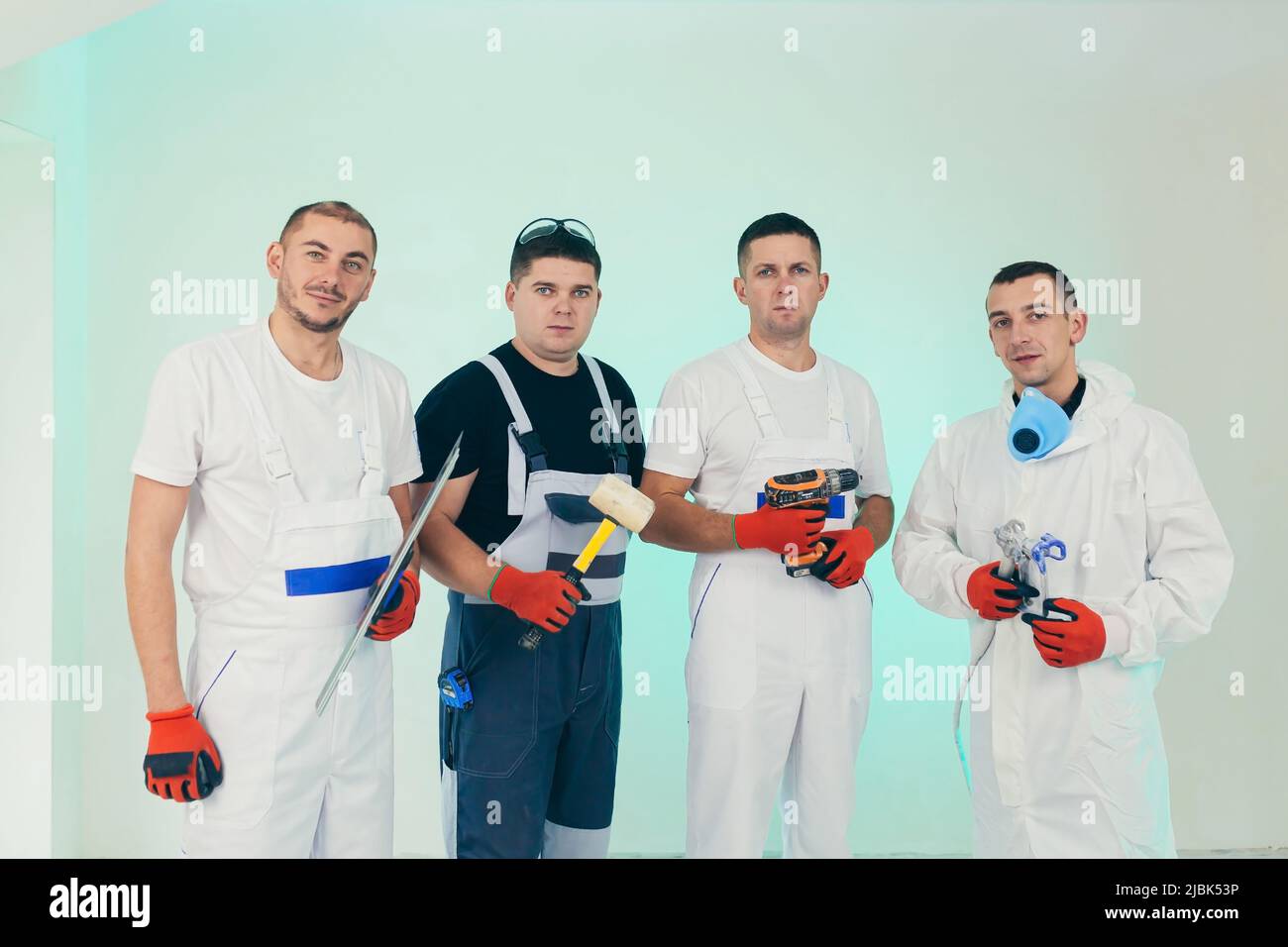 A team of construction workers, four people, men performing ...