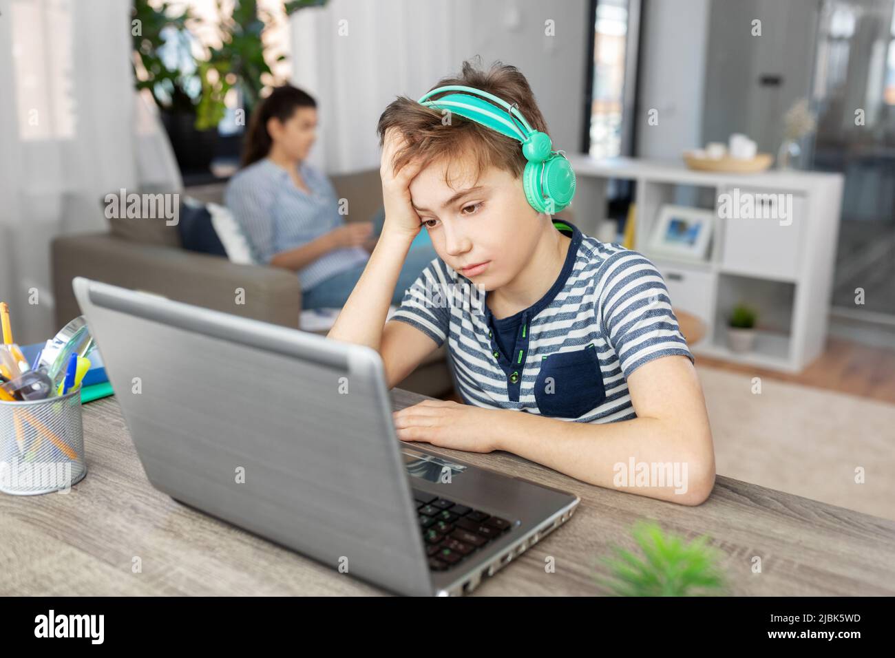 sad boy with laptop and headphones at home Stock Photo - Alamy
