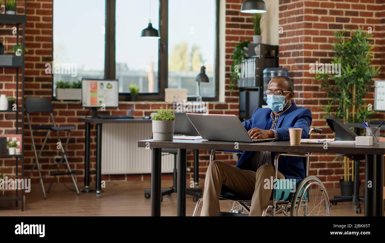 Wheelchair user working on business strategy in corporate space ...