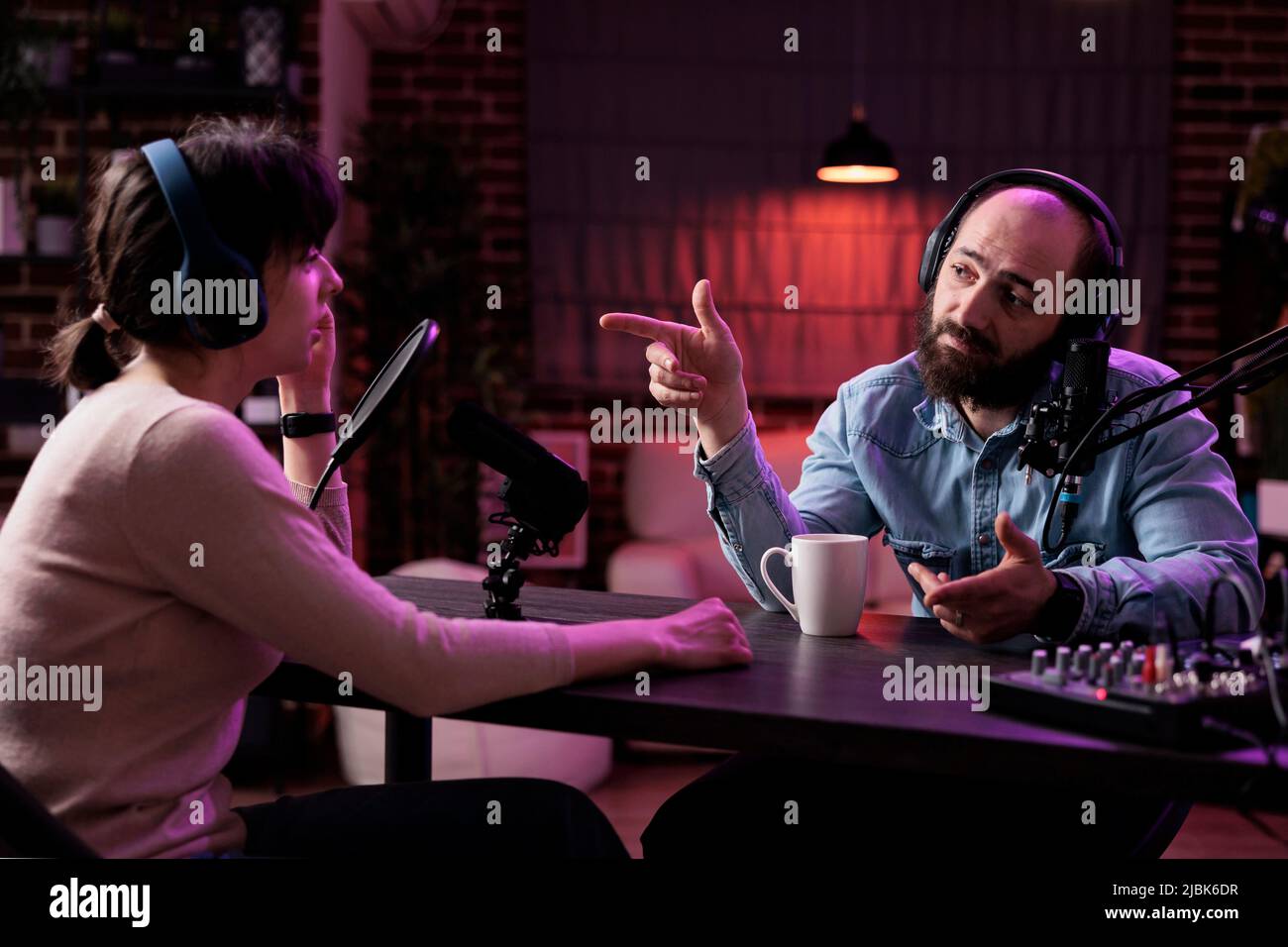 Male presenter interviewing woman on podcast discussion, talking to ...