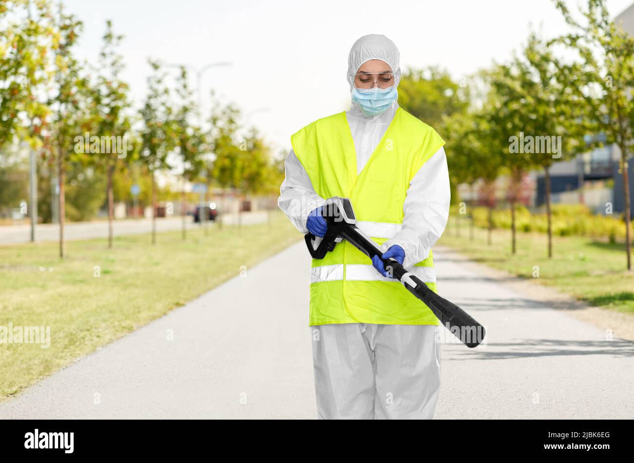 sanitation worker in hazmat with pressure washer Stock Photo - Alamy