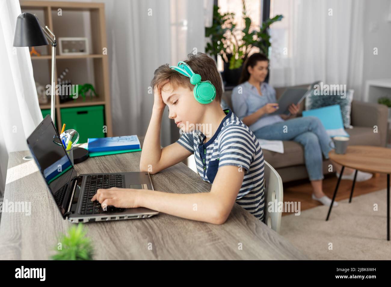 sad boy with laptop and headphones at home Stock Photo - Alamy