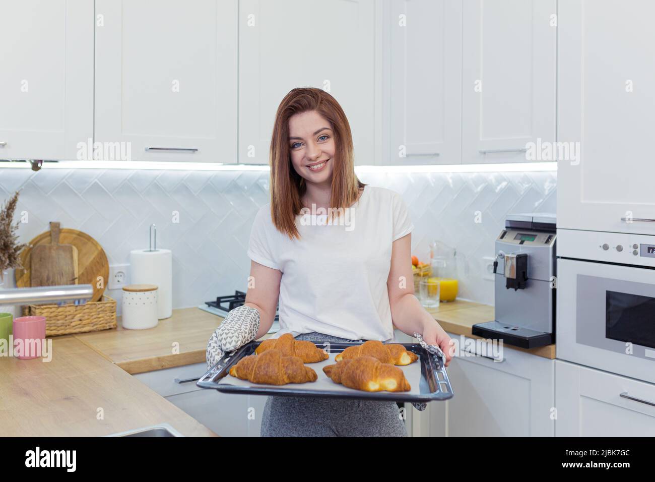 Young woman, mom baked croissants at home in the kitchen for family for ...