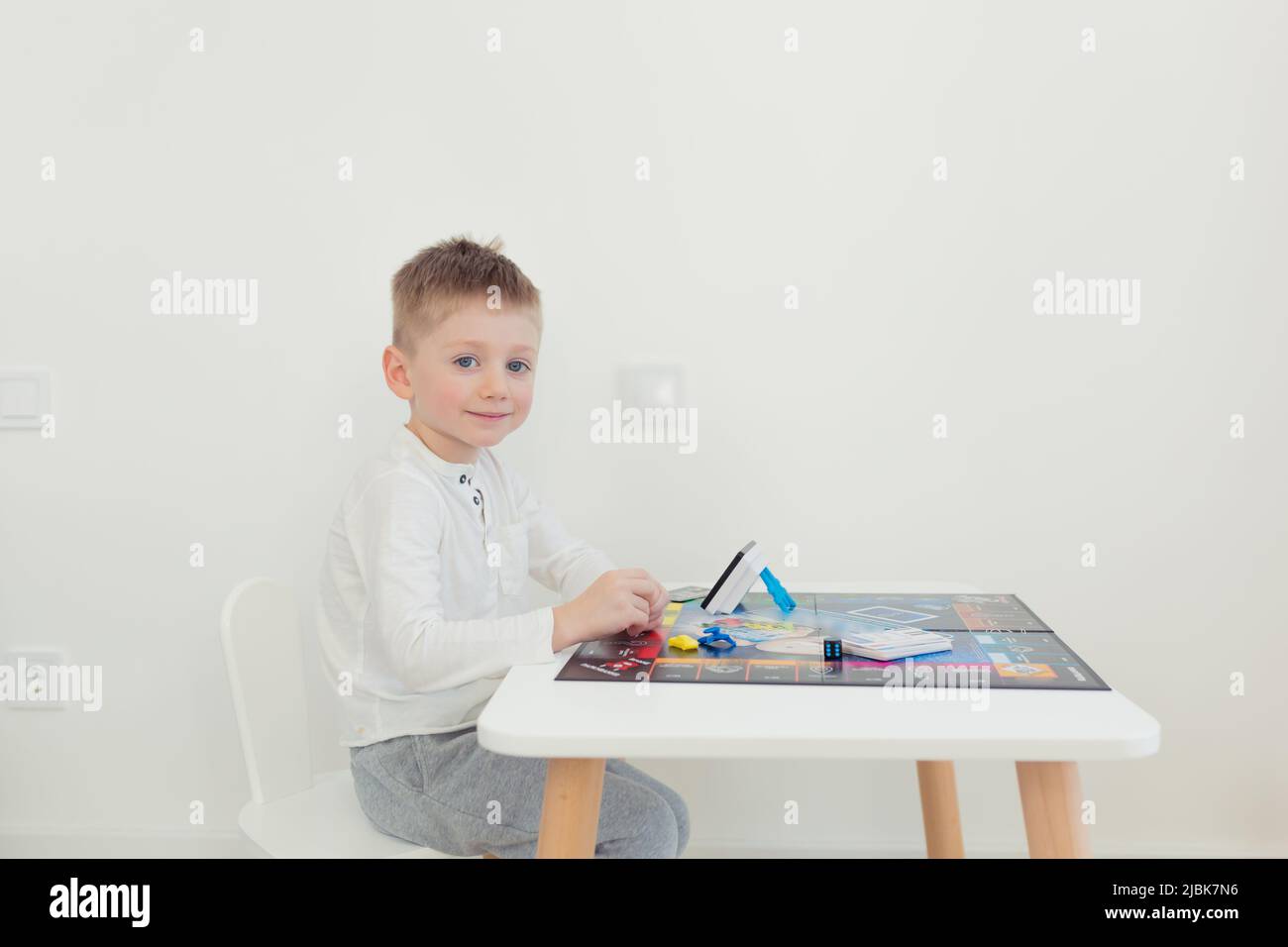 Little boy playing board game at the table in the nursery, smiling ...