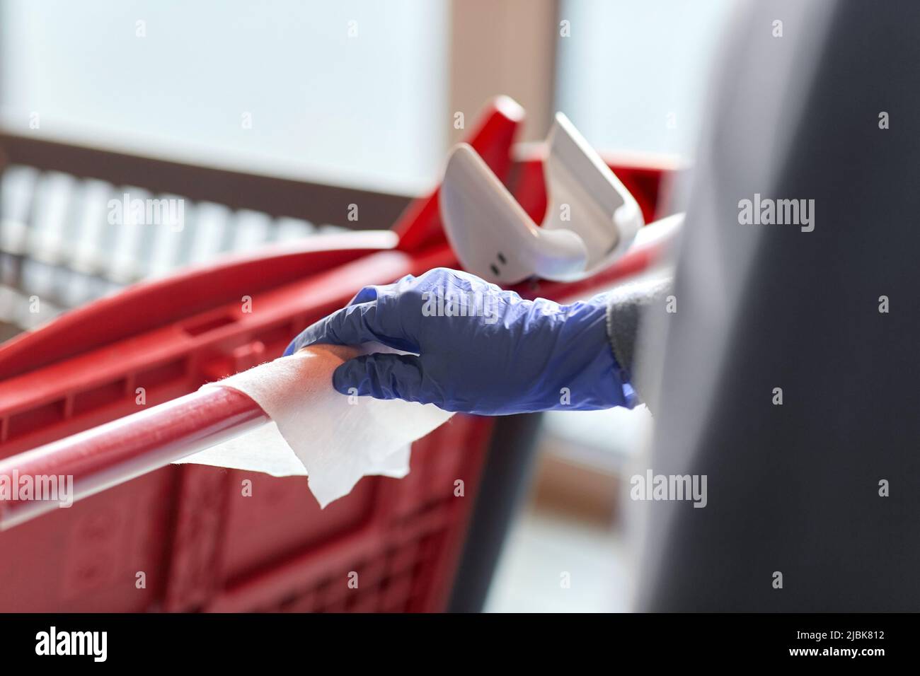hand cleaning shopping cart handle with wet wipe Stock Photo - Alamy