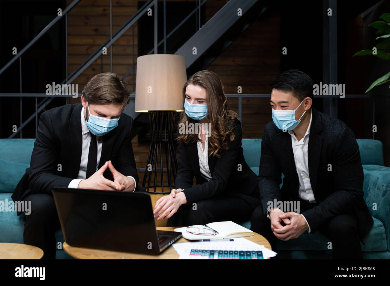 Group of men and woman hold business meeting, near laptop, wearing ...