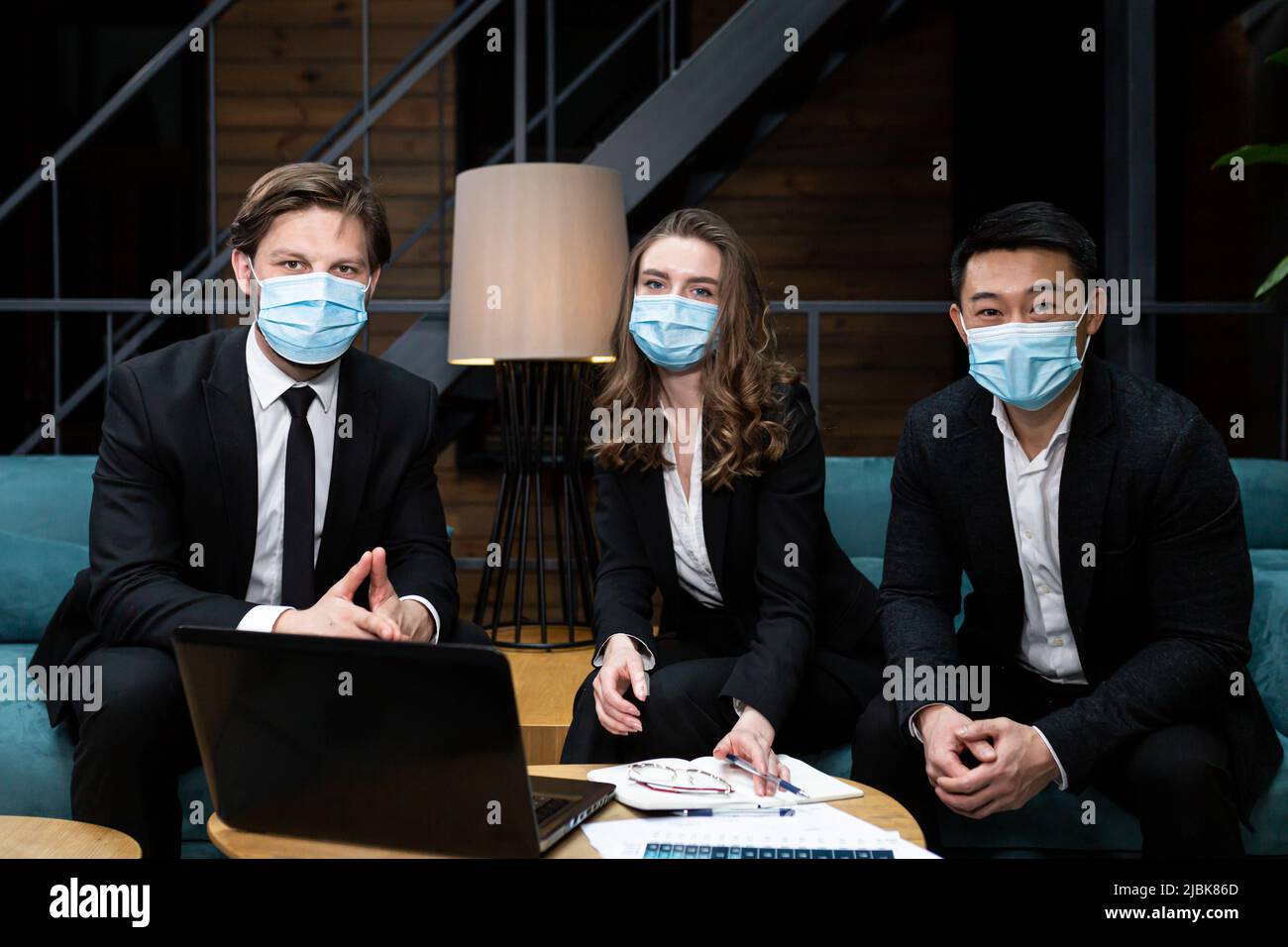 Group of men and woman hold business meeting, near laptop, wearing ...