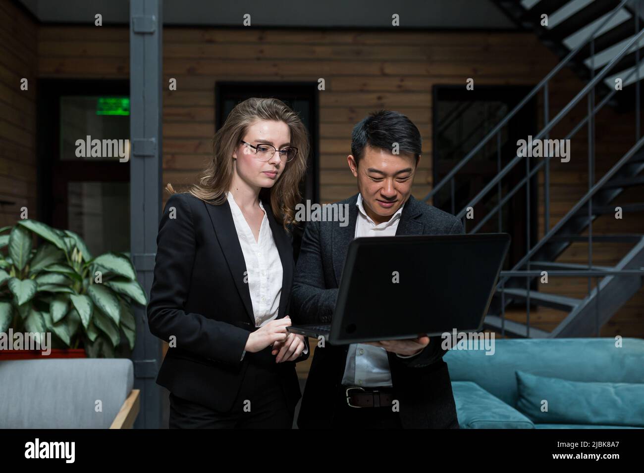 Businesswoman and an Asian investor are negotiating on IT technology ...