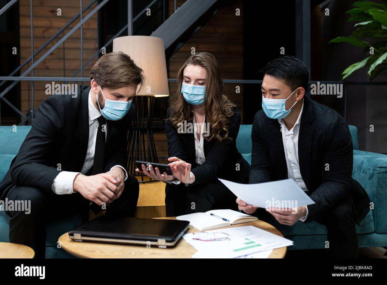 Group of men and woman hold business meeting, near laptop, wearing ...