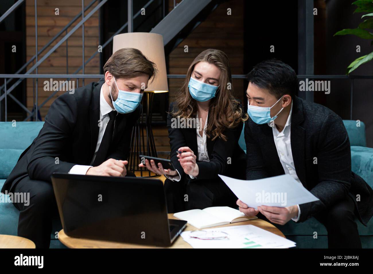 Group of men and woman hold business meeting, near laptop, wearing ...