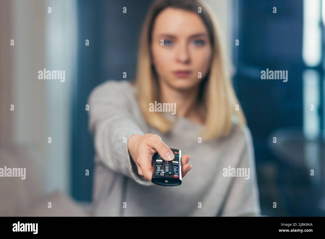 Close-up photo, portrait of a young girl holding a remote control and ...