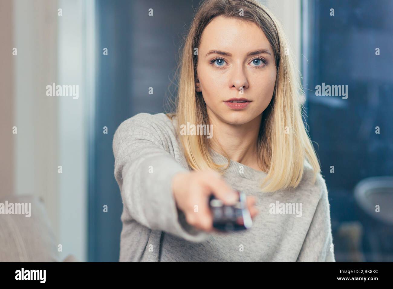 Close-up photo, portrait of a young girl holding a remote control and ...