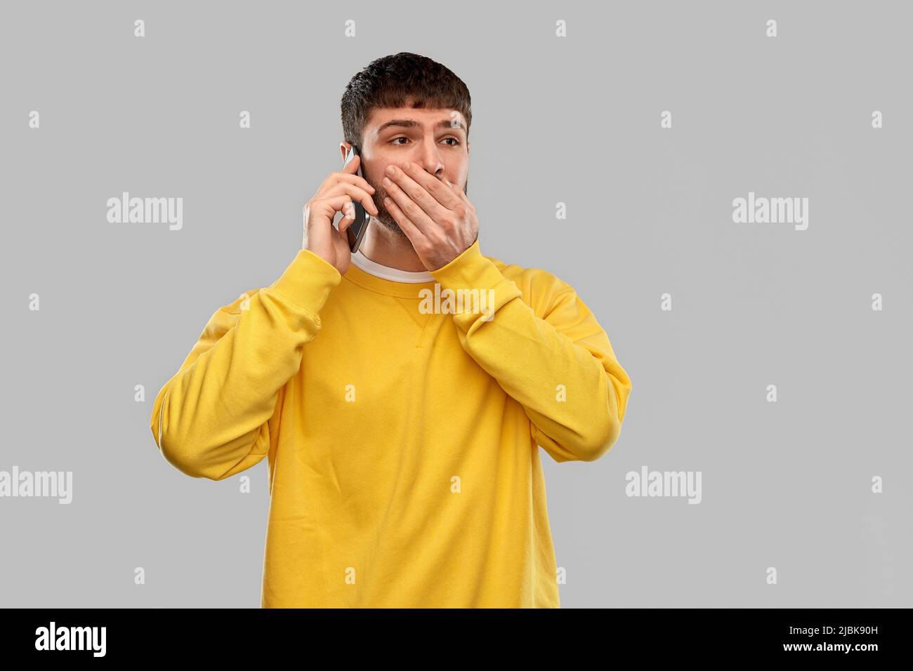 shocked young man calling on smartphone Stock Photo - Alamy