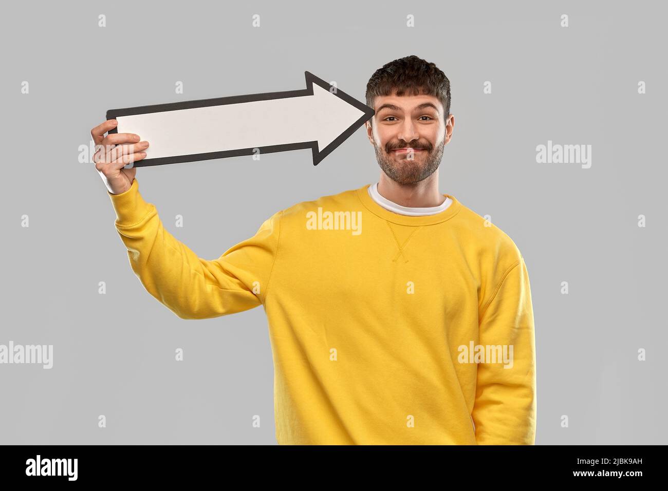 Smiling young man pointing right hi-res stock photography and images ...