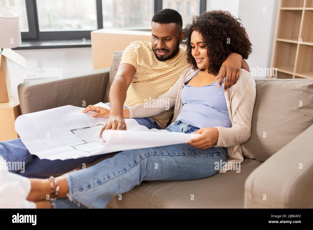 couple with boxes and blueprint moving to new home Stock Photo - Alamy