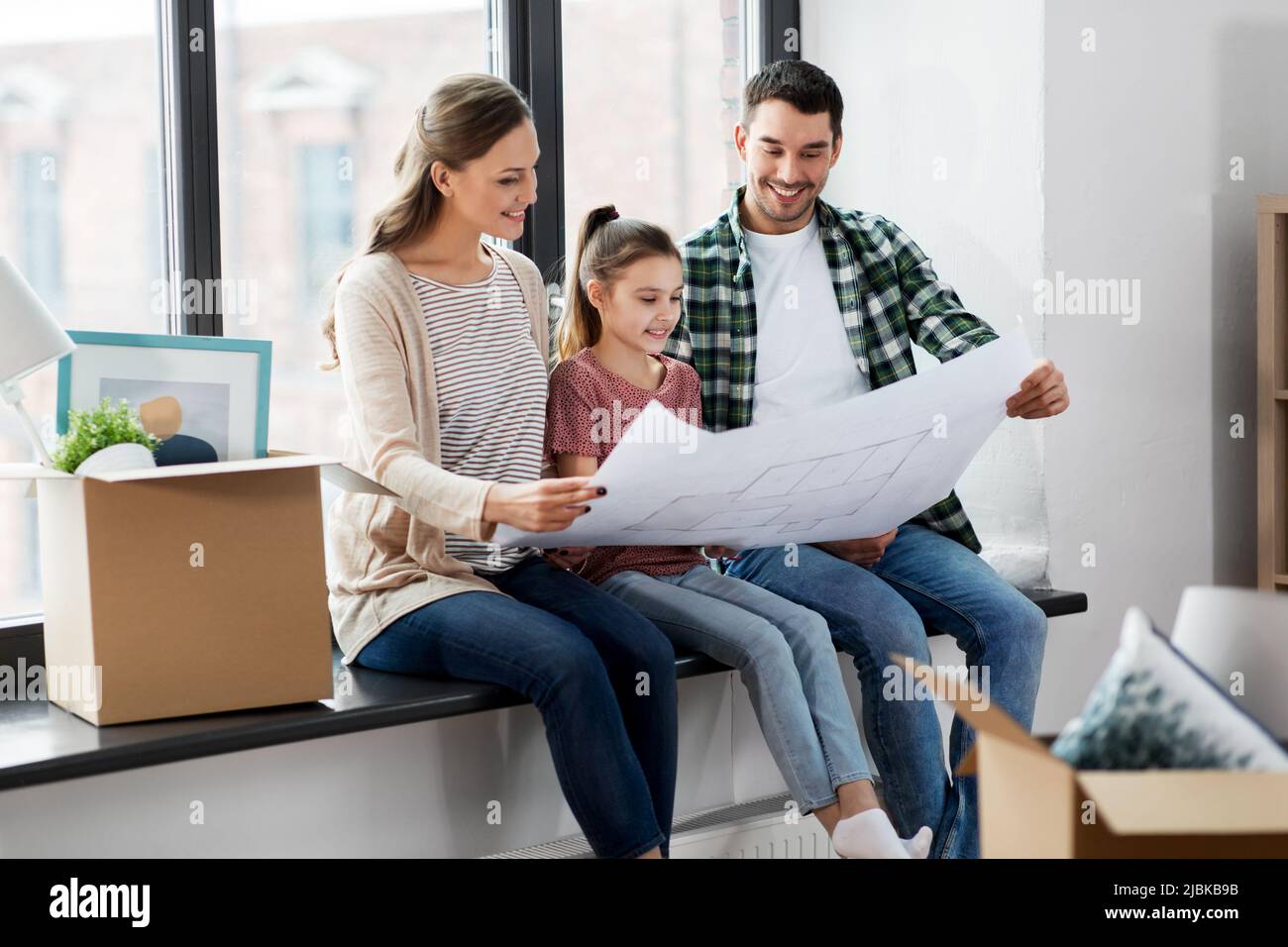 happy family with blueprint moving to new home Stock Photo - Alamy