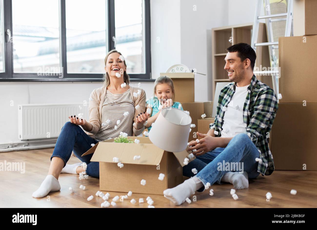 happy family playing with foam peanuts at new home Stock Photo - Alamy