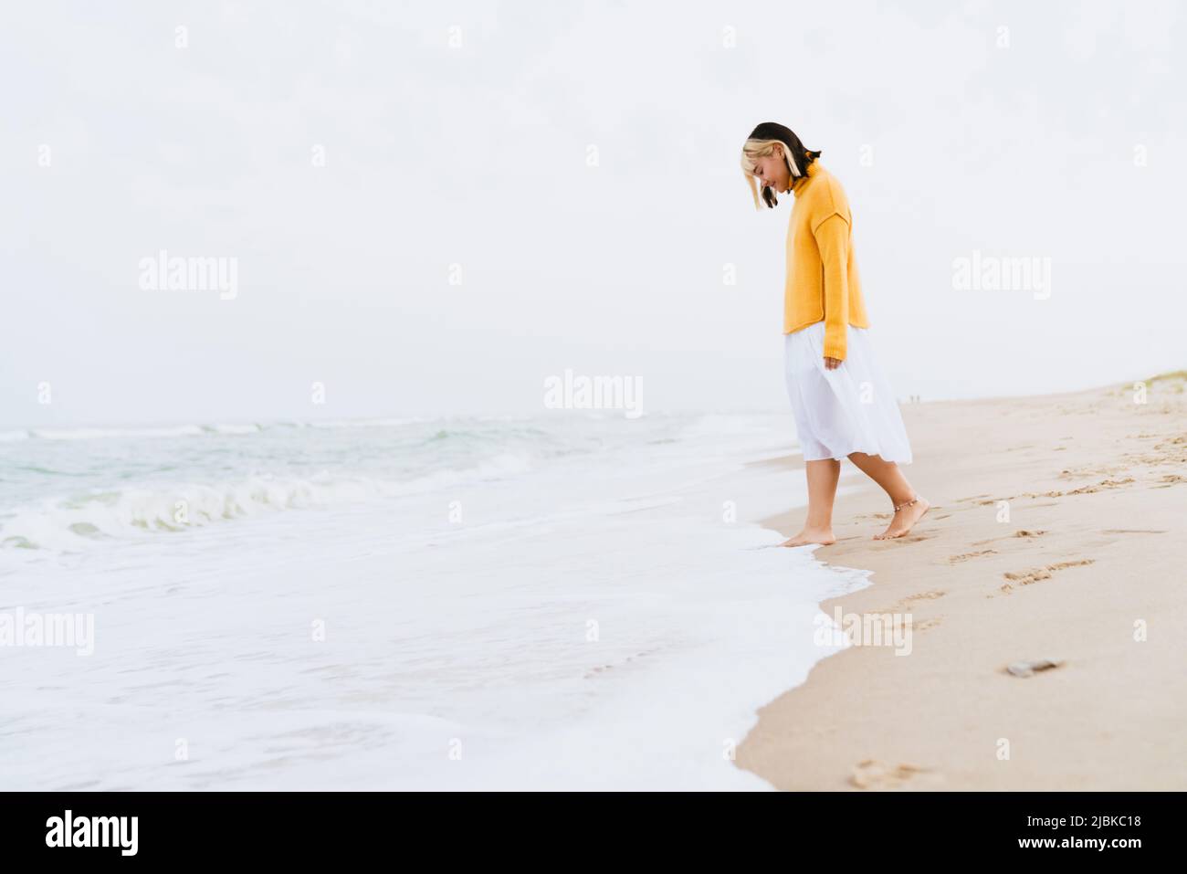 Young asian woman wearing sweater smiling during walking on beach Stock ...