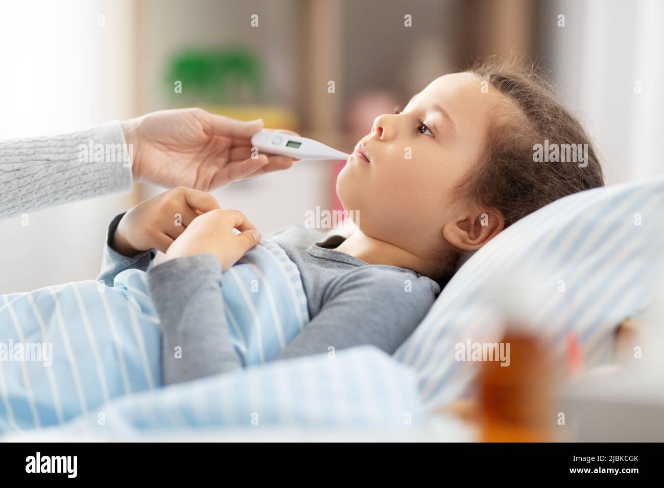 mother and sick daughter measuring temperature Stock Photo - Alamy