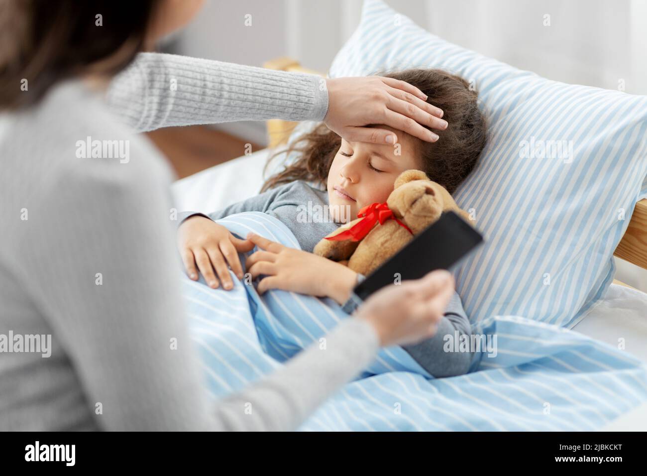 sick daughter and mother with phone at home Stock Photo - Alamy
