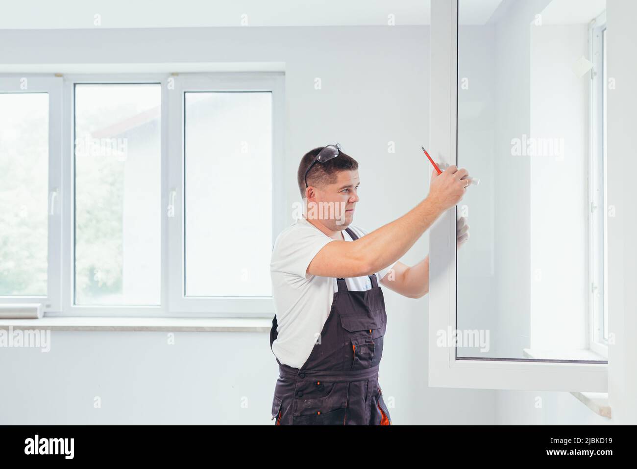 The worker adjusts the window in the apartment of the house after ...