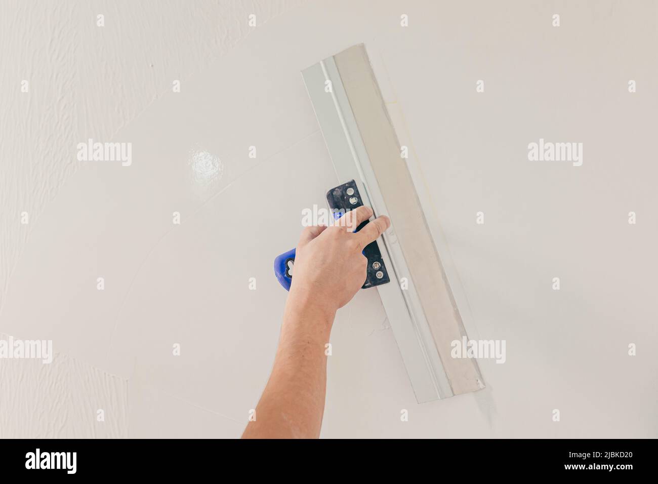Construction spatula with putty glue, photo from close hand of worker ...