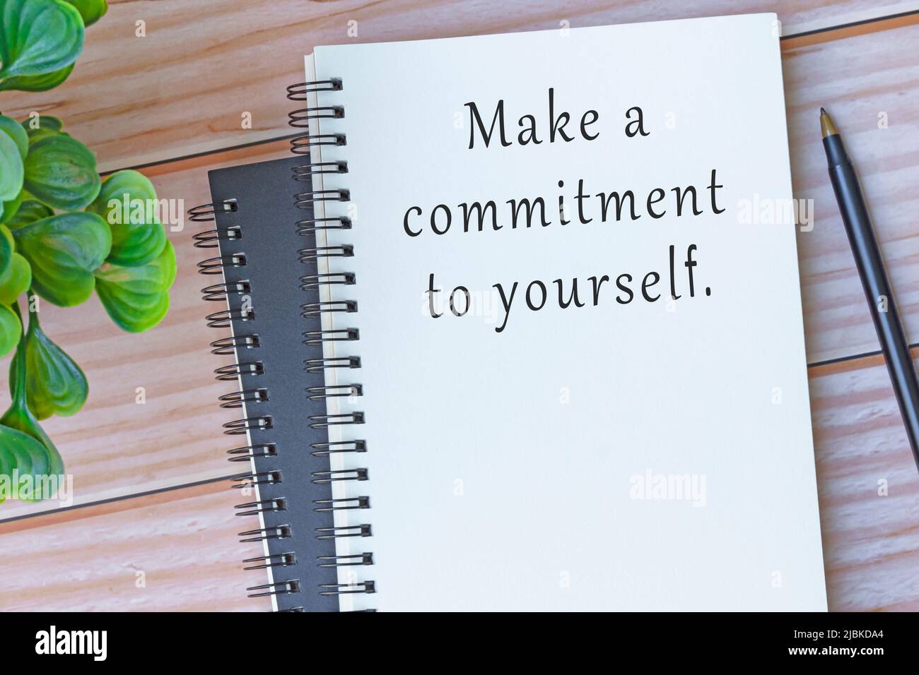 Motivational and inspirational quote on note book on wooden desk - Make a commitment to yourself ...