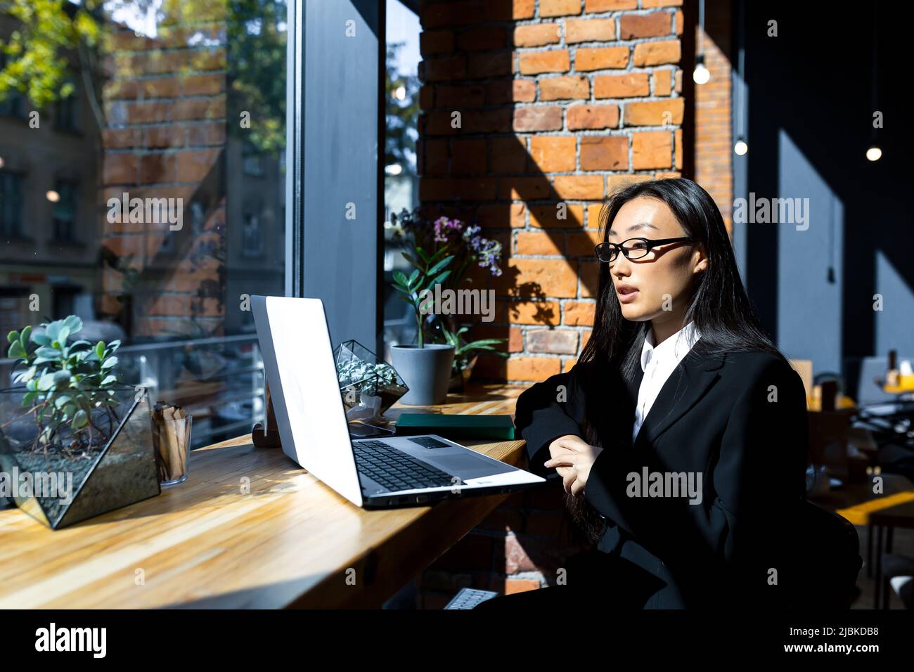 Business woman freelancer working in a cafe on a laptop remotely ...
