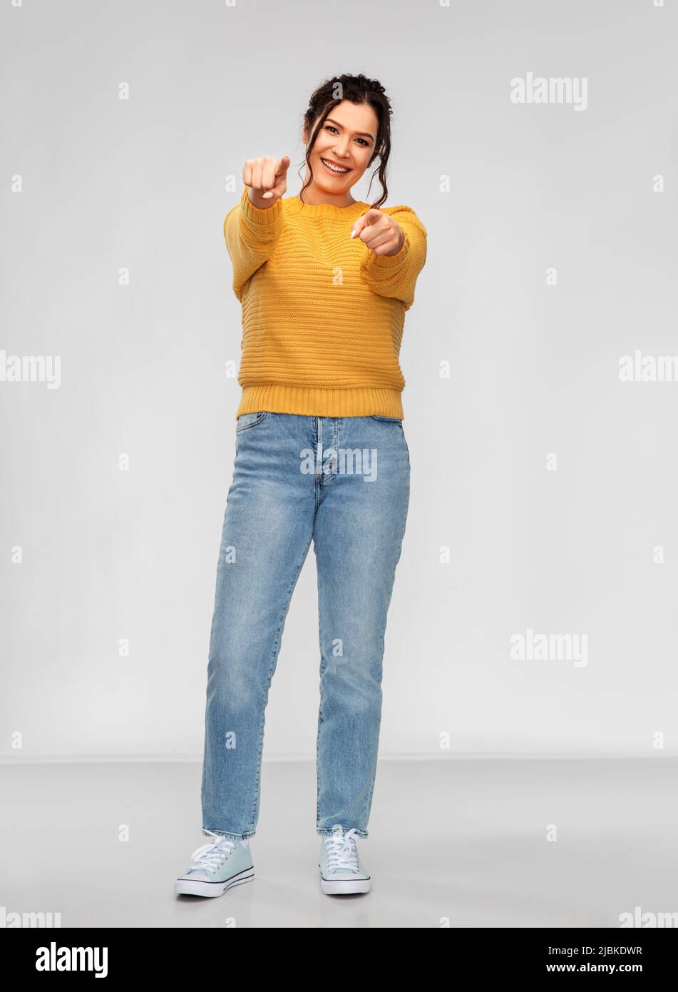 smiling young woman pointing finger to camera Stock Photo - Alamy