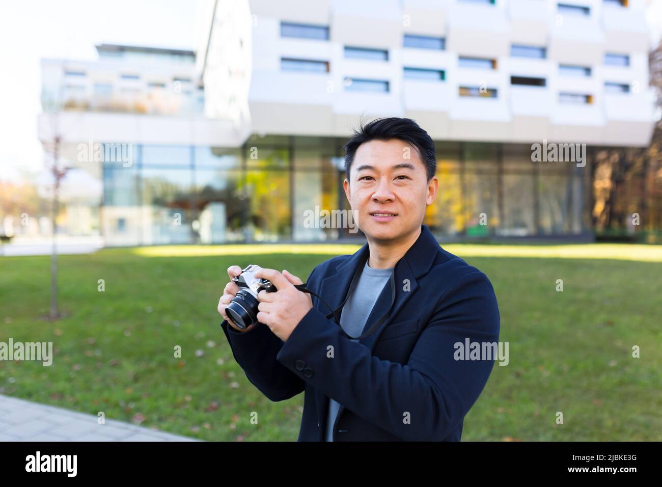Male asian photographer, tourist makes photo camera Stock Photo - Alamy