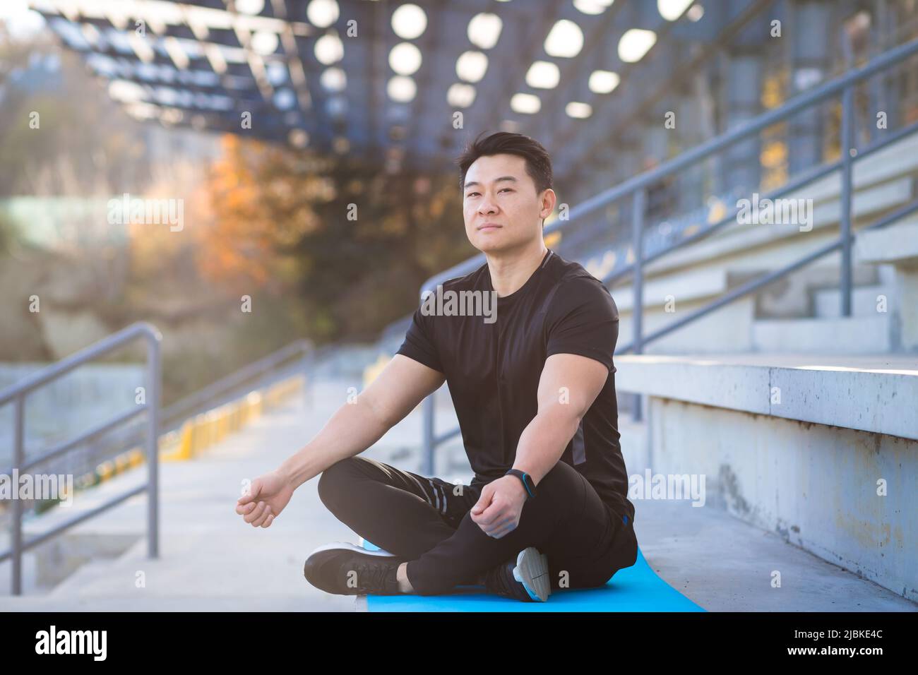 Successful athlete sitting in lotus position in the morning meditating ...