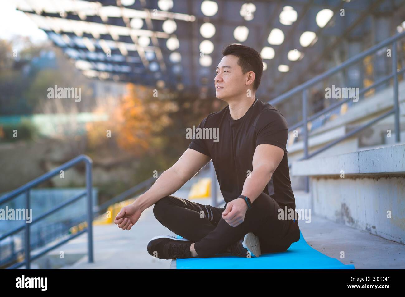 Successful athlete sitting in lotus position in the morning meditating ...