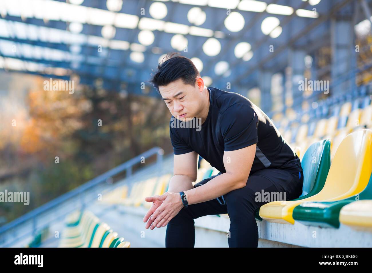 Frustrated Asian male athlete depressed, dissatisfied with the result ...