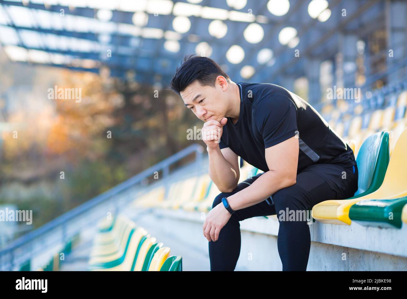 Frustrated Asian male athlete depressed, dissatisfied with the result ...