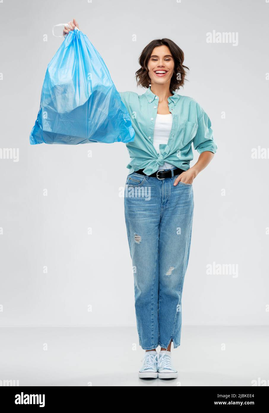 smiling woman holding plastic trash bag with waste Stock Photo - Alamy