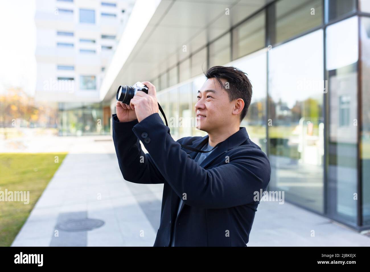 Male asian photographer, tourist makes photo camera Stock Photo - Alamy