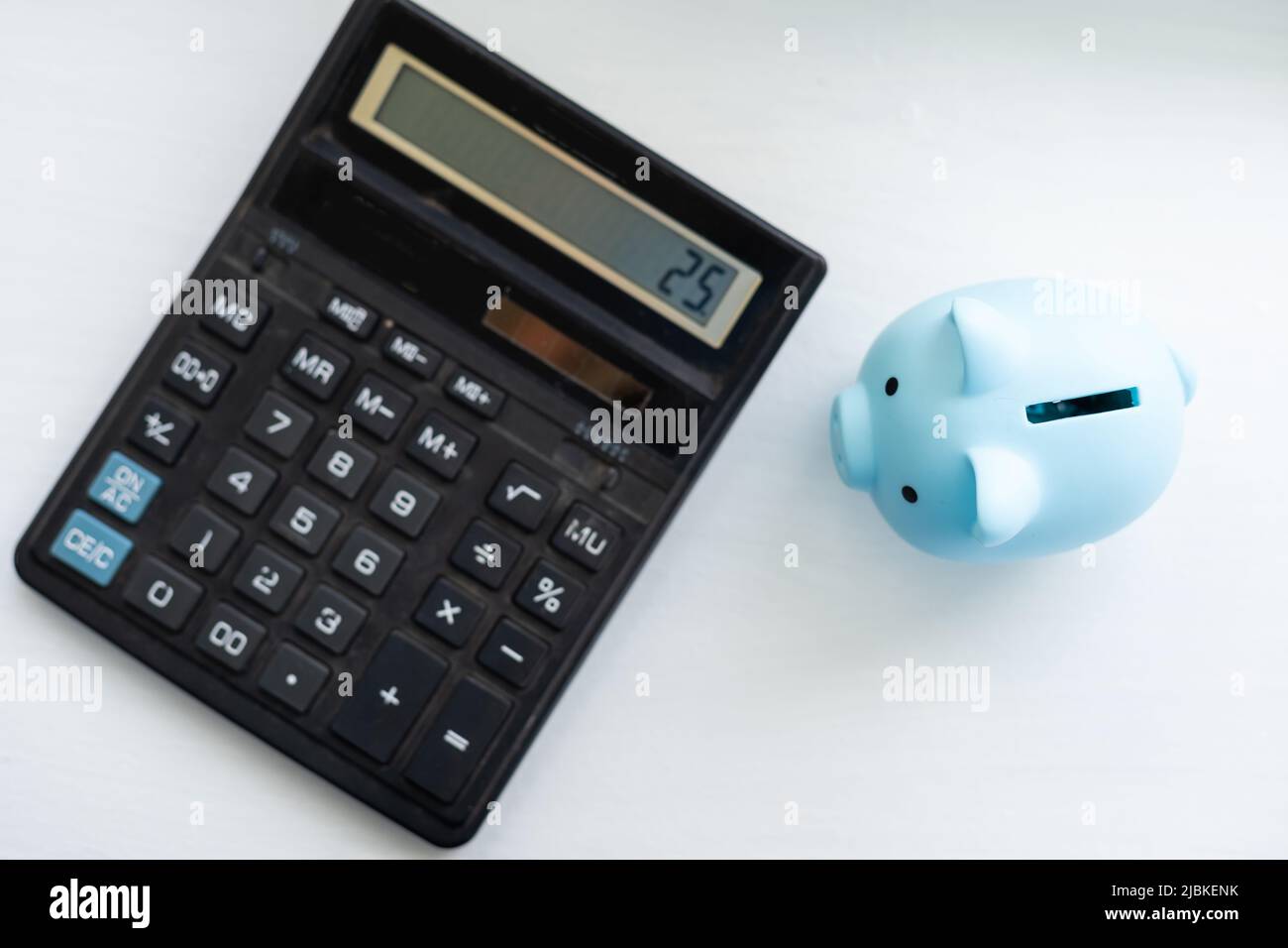 Piiggy bank with calculator close-up on blue pastel background ...