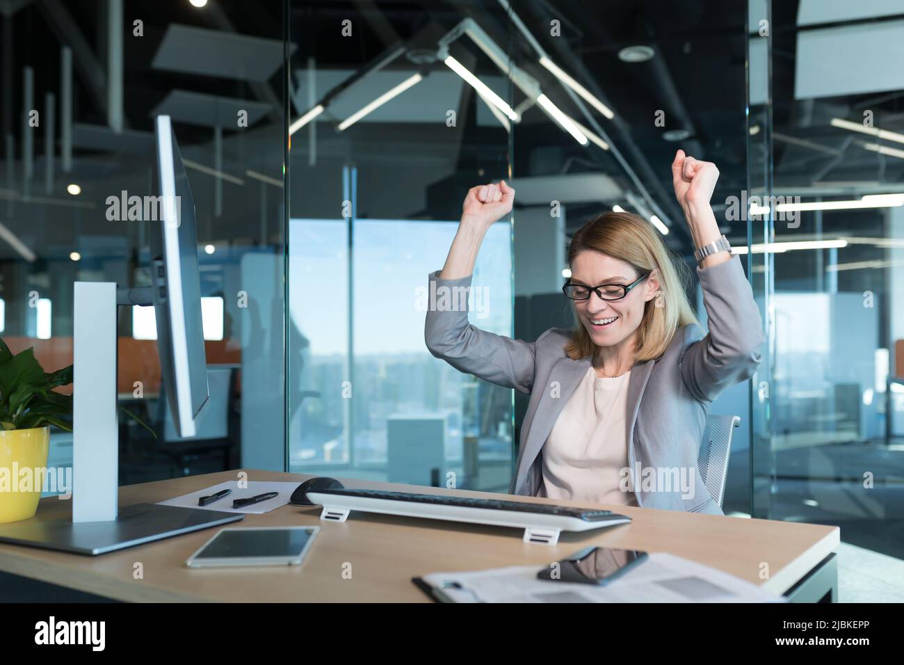 Beautiful and successful business woman with glasses, celebrating ...