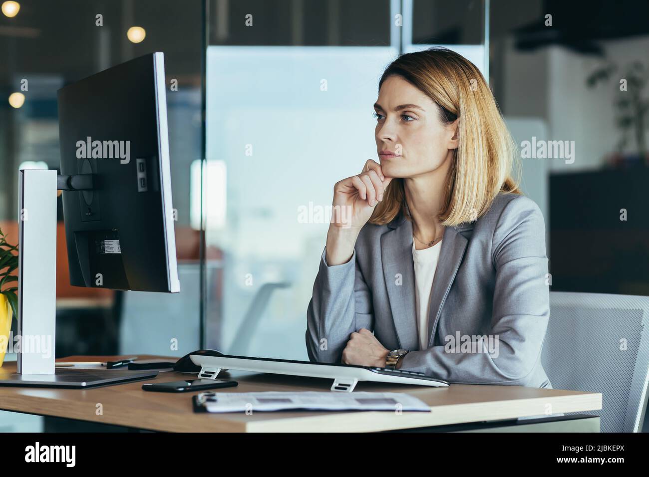 Thinking business woman looking at computer monitor, business woman ...