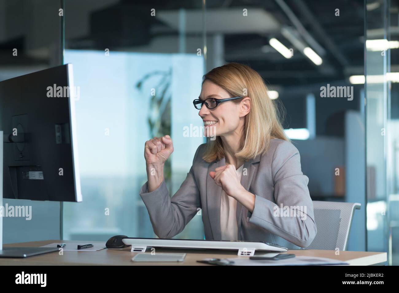 Beautiful and successful business woman with glasses, celebrating ...