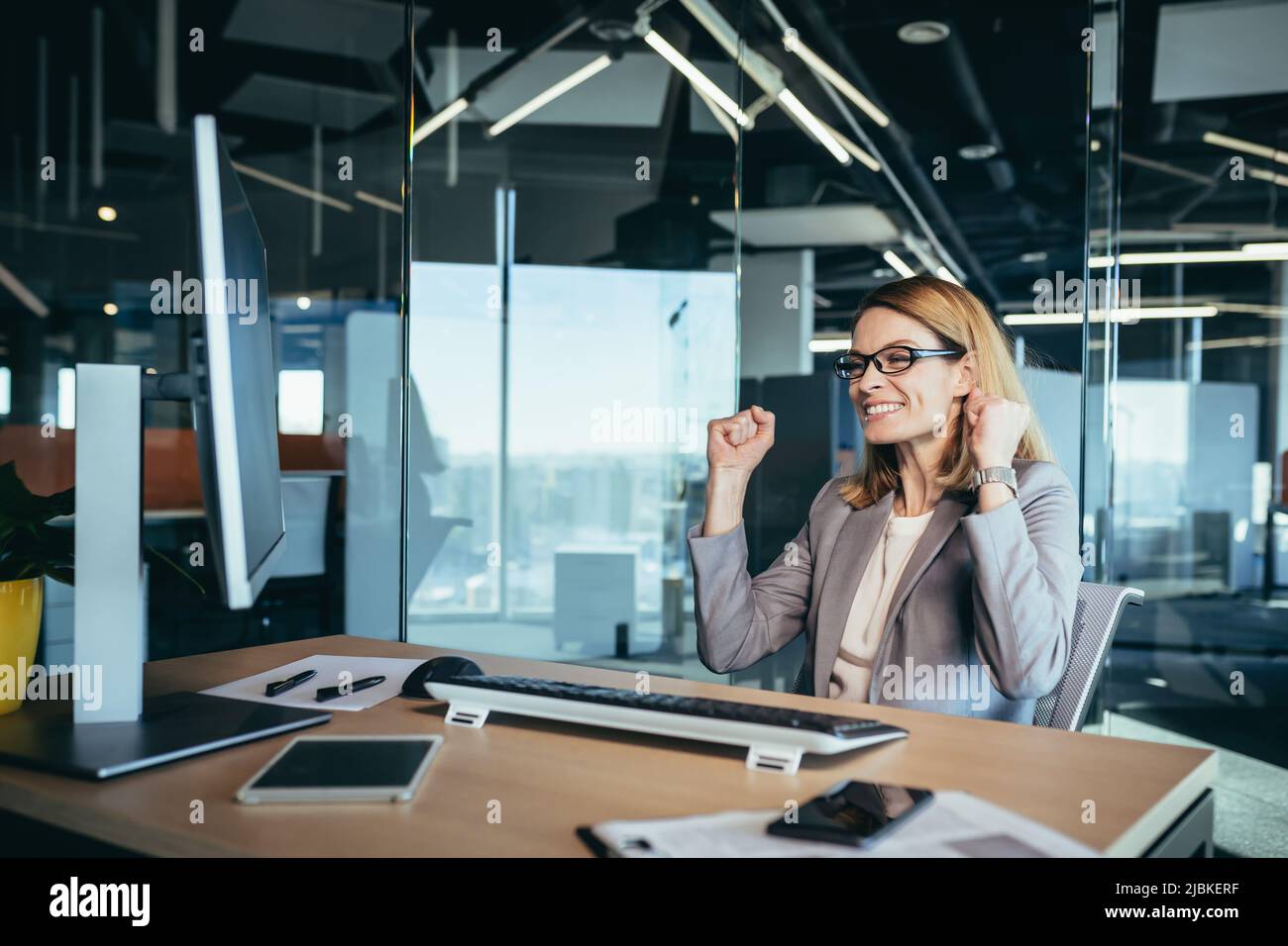 Beautiful and successful business woman with glasses, celebrating ...