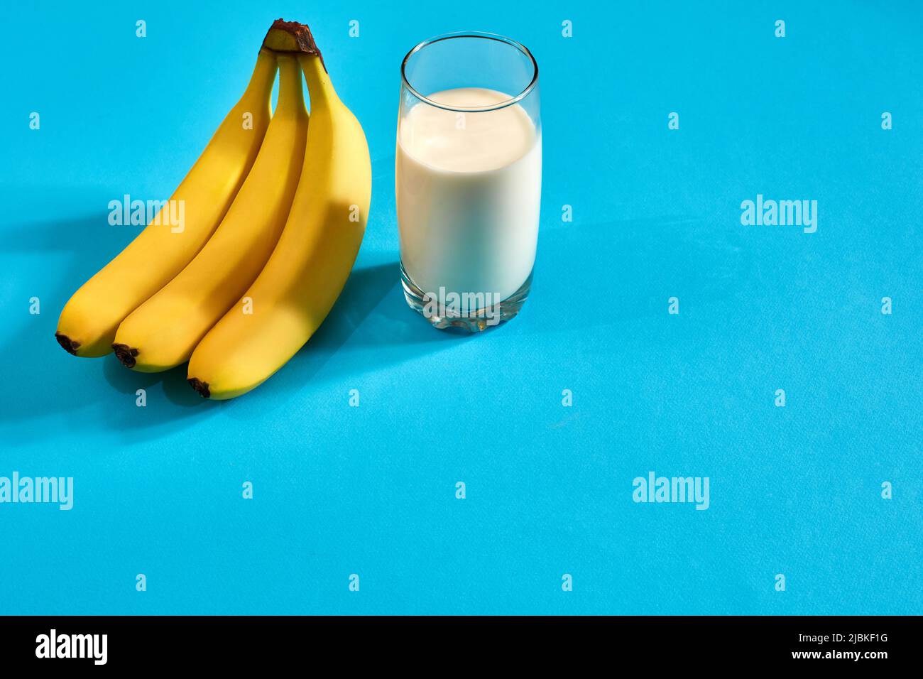 Glass of milk with bananas over blue background Stock Photo - Alamy