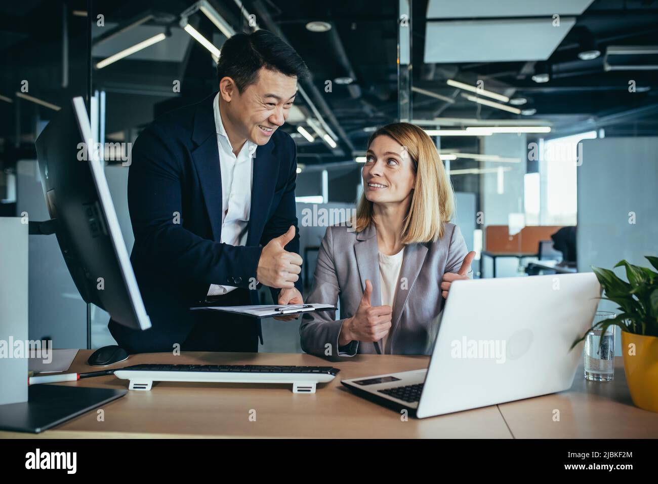 two business people consulting on a project looking at computer monitor ...
