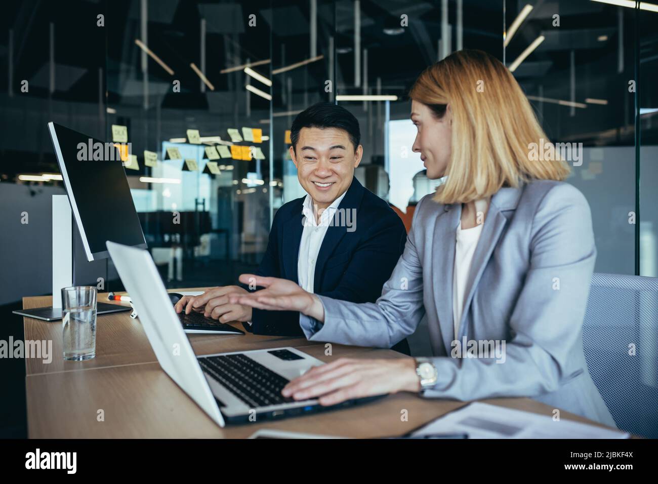 happy coworkers discuss project strategy by looking and pointing at ...