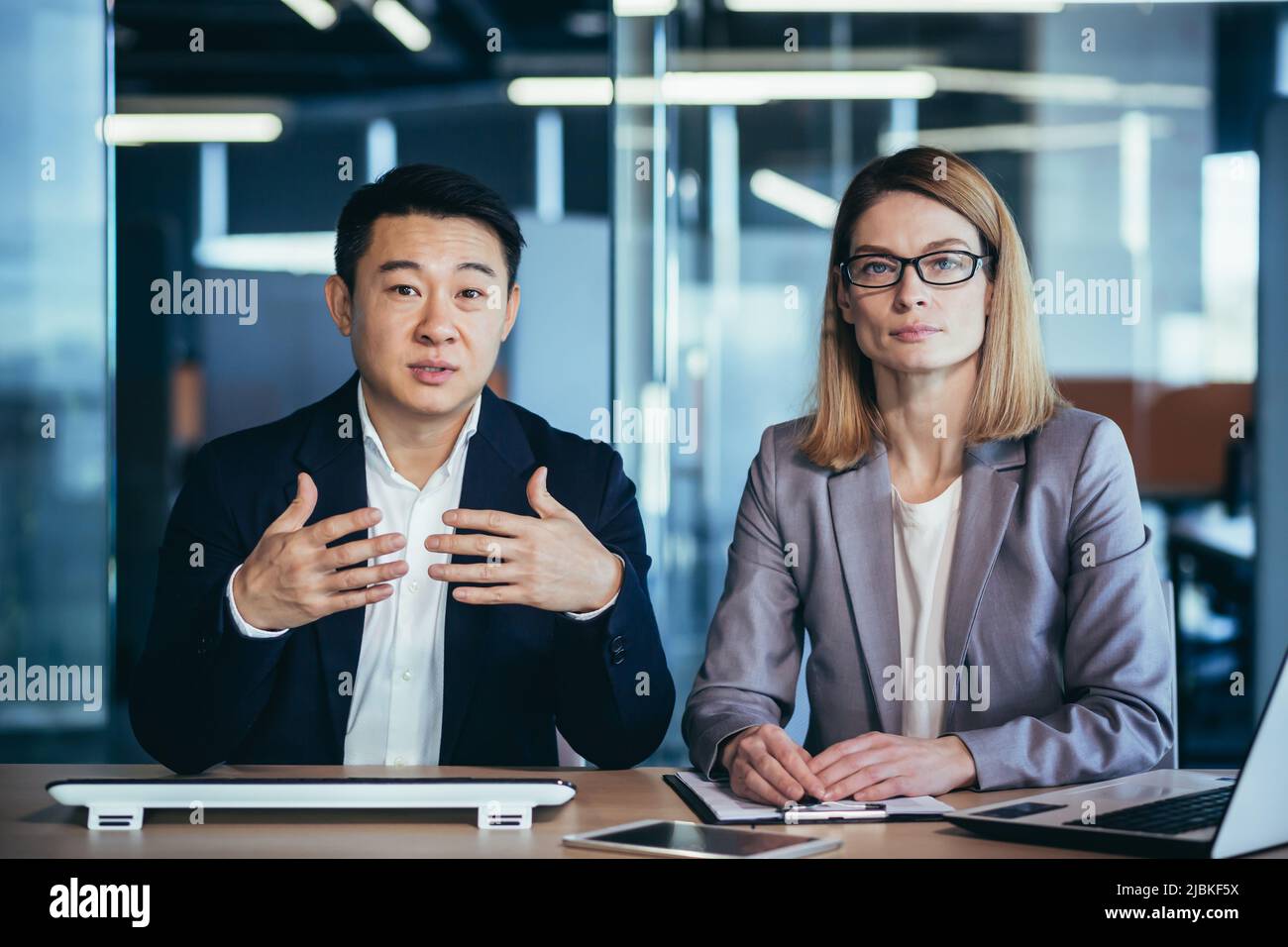 a team of business employees at an online meeting look at camera and ...