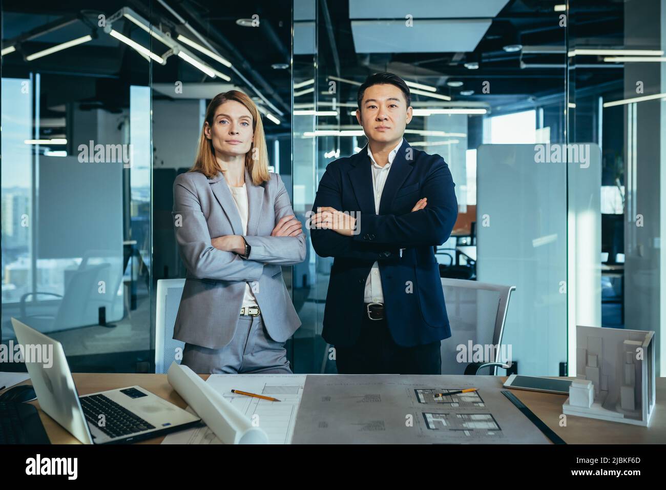 A team of two business people, an Asian man and a woman, look ...