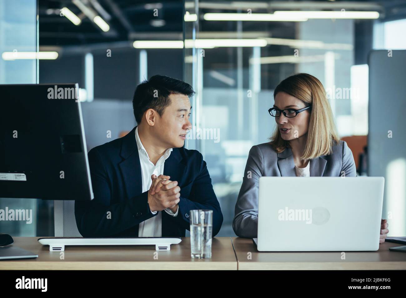 Friendly conversation of colleagues at work in the office. Asian man ...