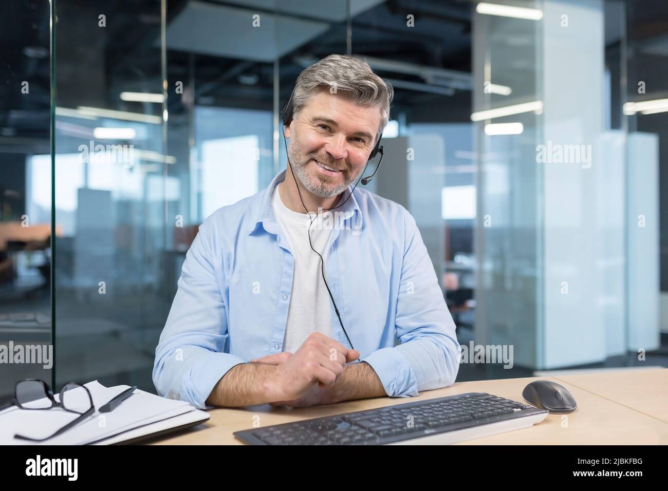 Experienced and successful businessman, looks at the webcam and smiles ...