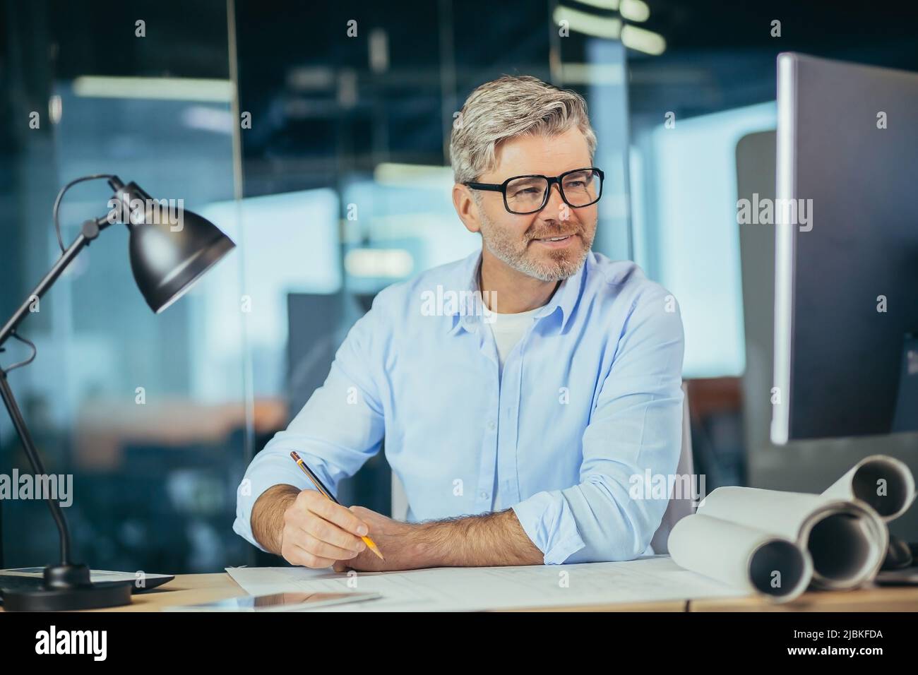 Experienced designer architect works at the table draws a draft plan of ...
